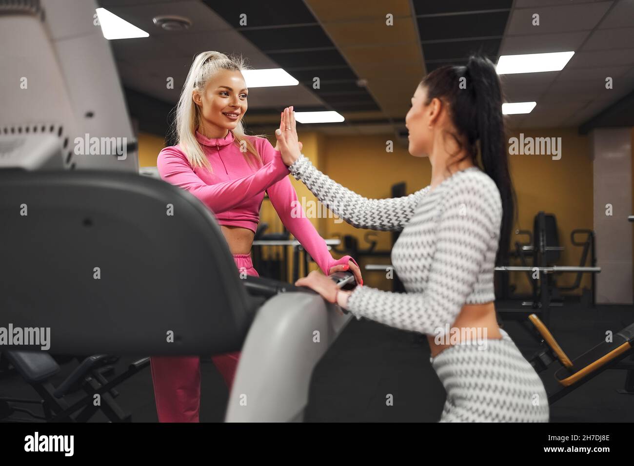 Female personal trainer supports woman client after running on ...