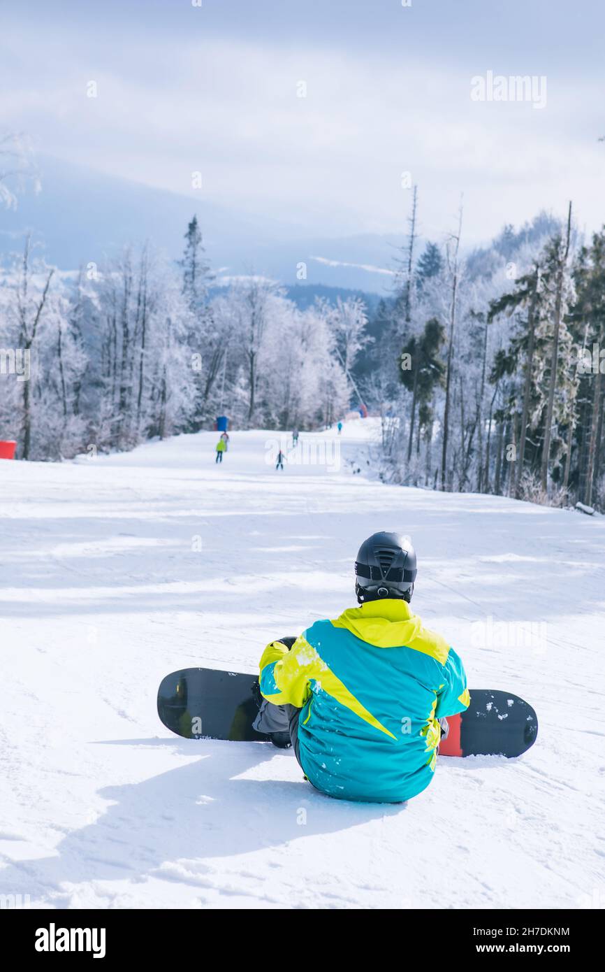 man sitting on the top of the hill enjoying view. snowboarding. winter ...