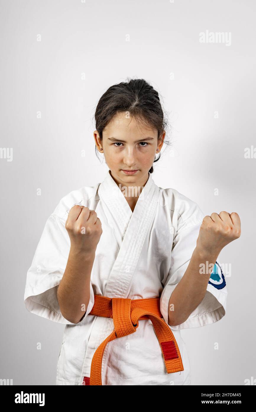 Karate girl on a white background. An athletic Caucasian brunette in a ...