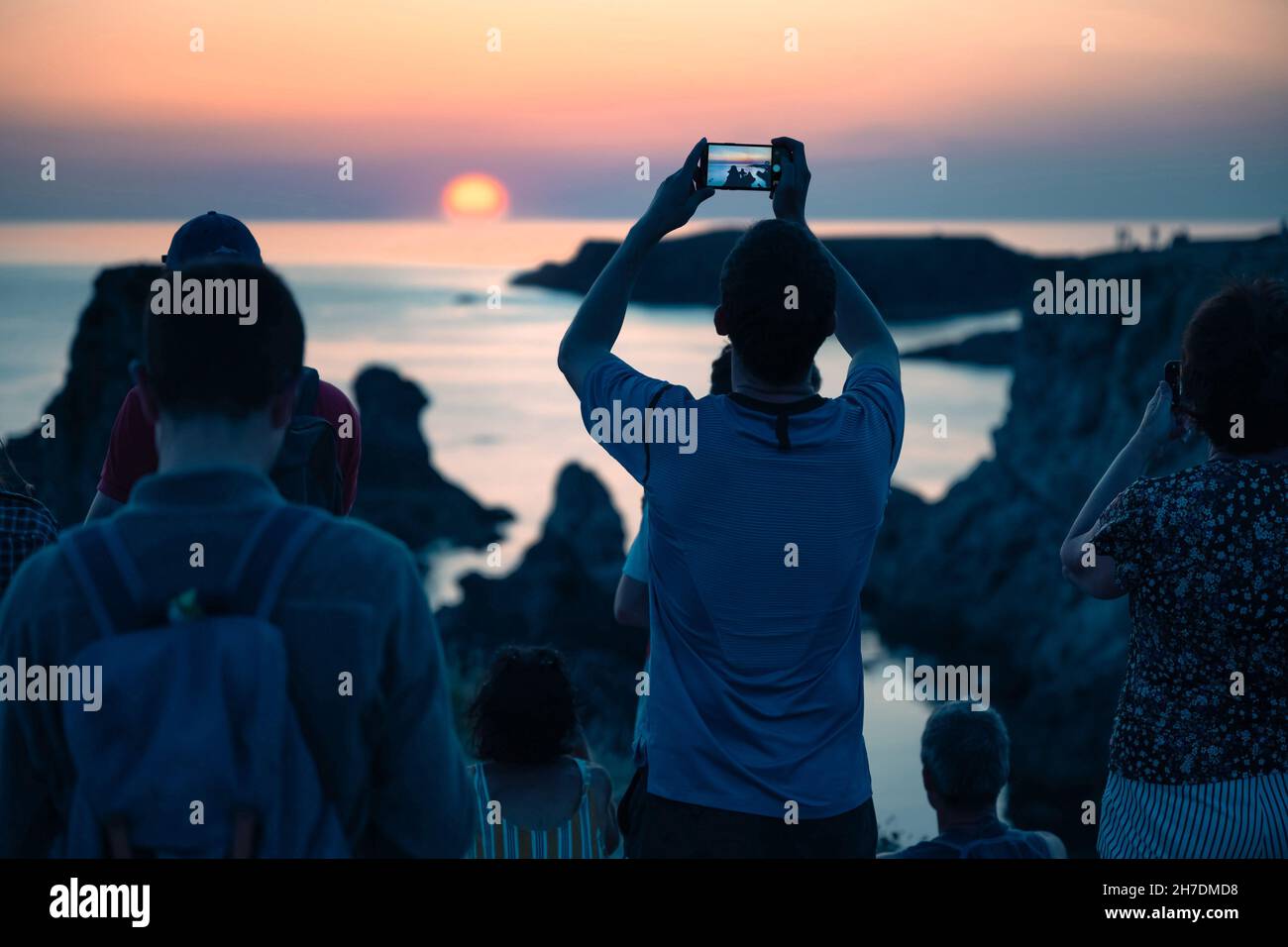 View of over a group of tourists taking sunset photographs Stock Photo ...
