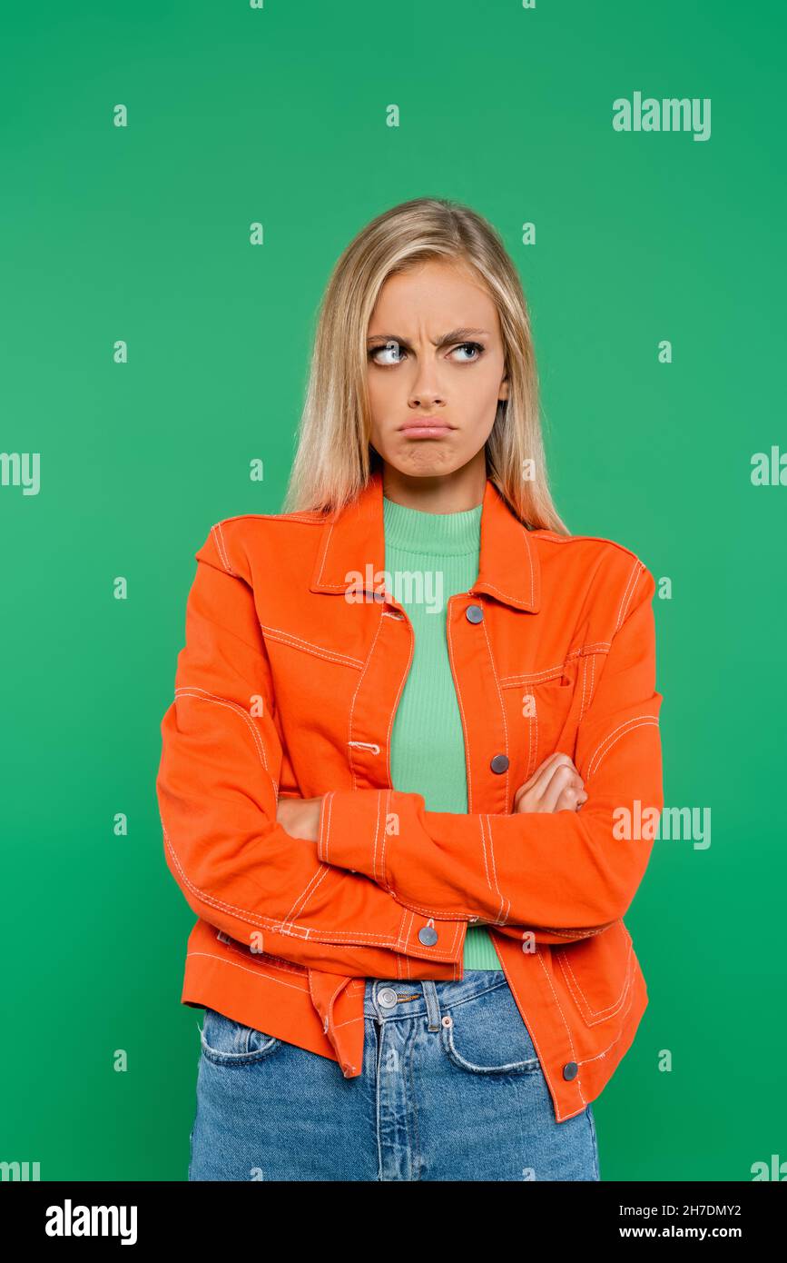 offended woman frowning and pouting lips while standing with crossed ...