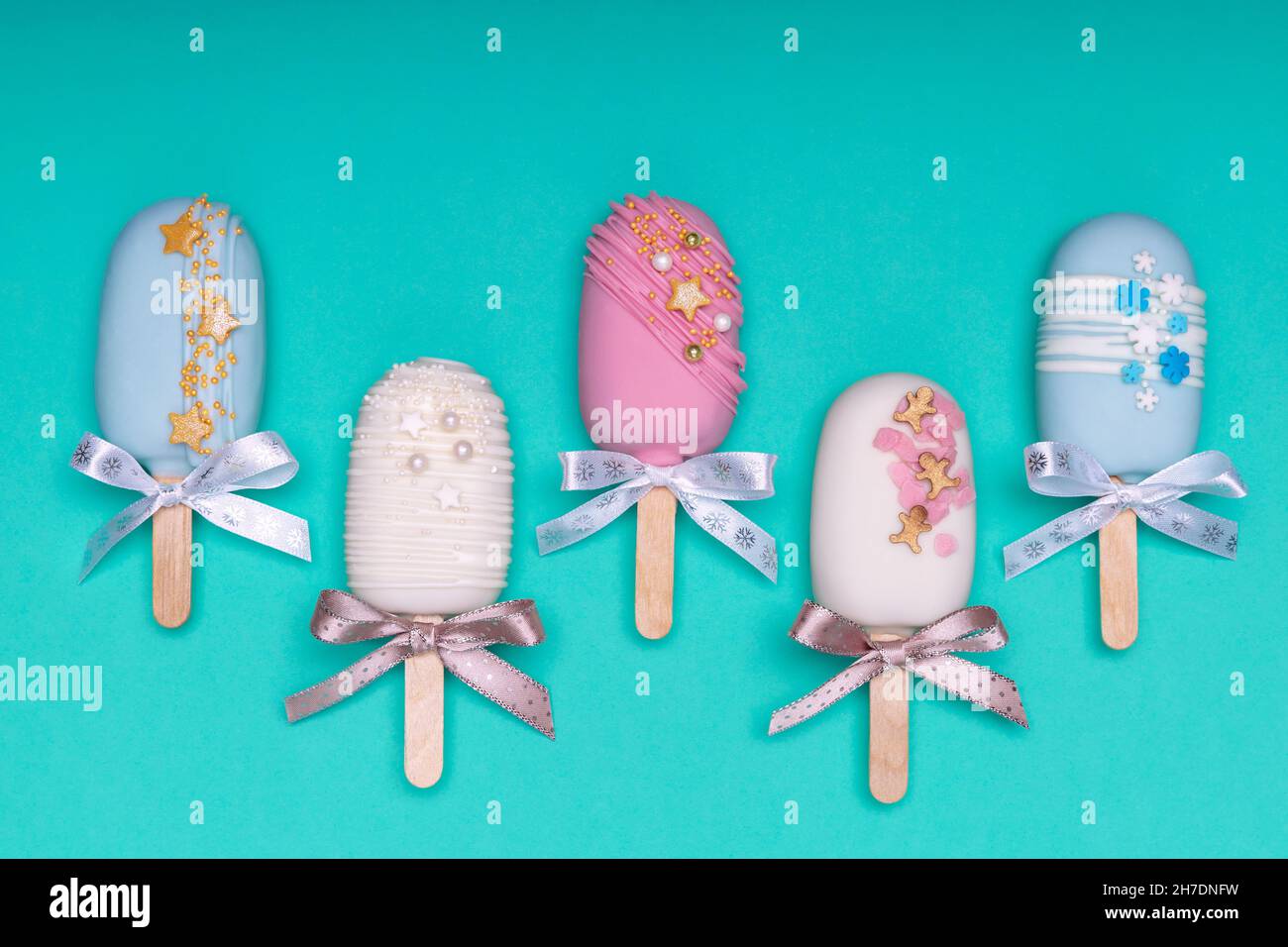 top view of decorated cake pops ice creams on turquoise background ...