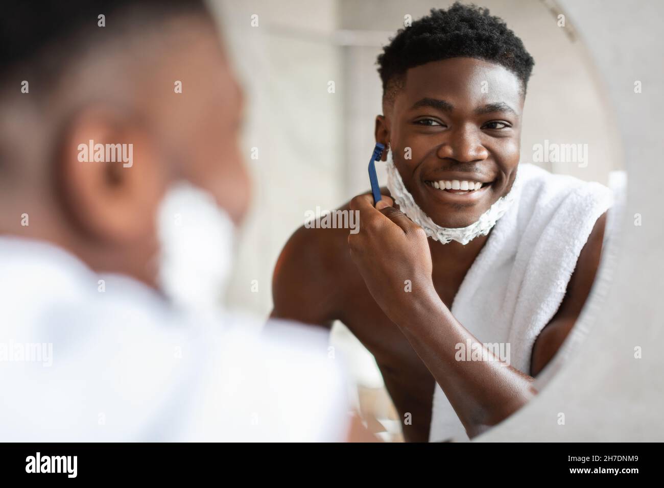 Handsome Black Guy Shaving Face With Safety Razor In Bathroom Stock ...