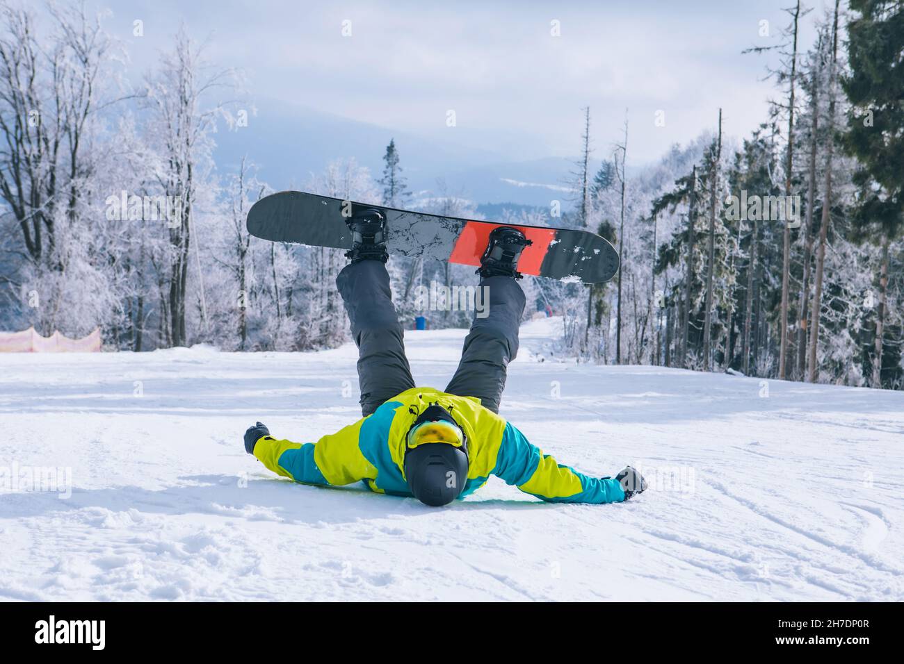 man laying on back lags with snowboard above head having fun Stock ...