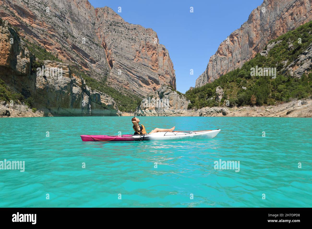 Side view portrait of a woman relaxing on kayak resting in a lake on ...