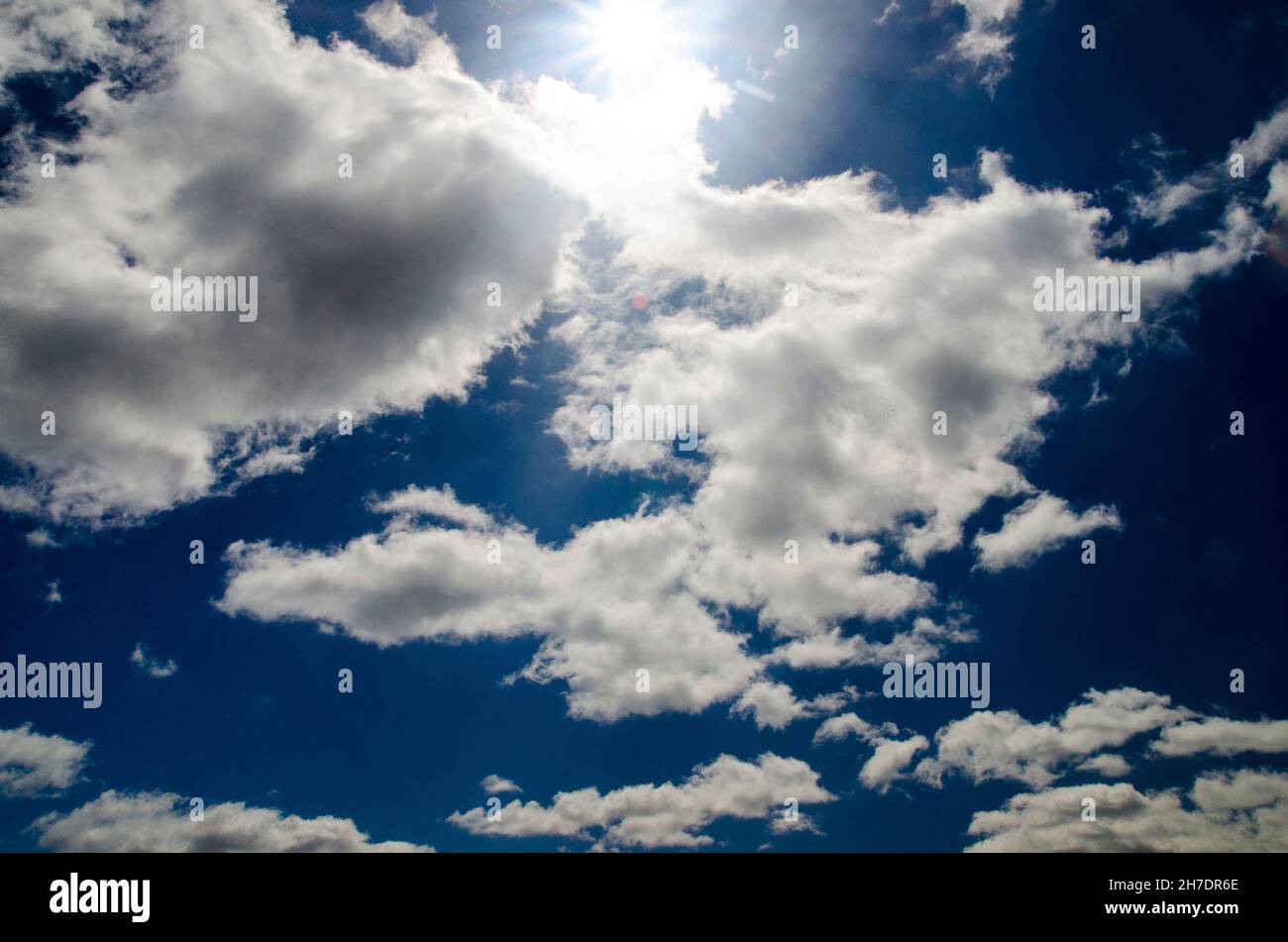 Sun in the deep blue sky, beautiful clouds and sun rays Stock Photo - Alamy