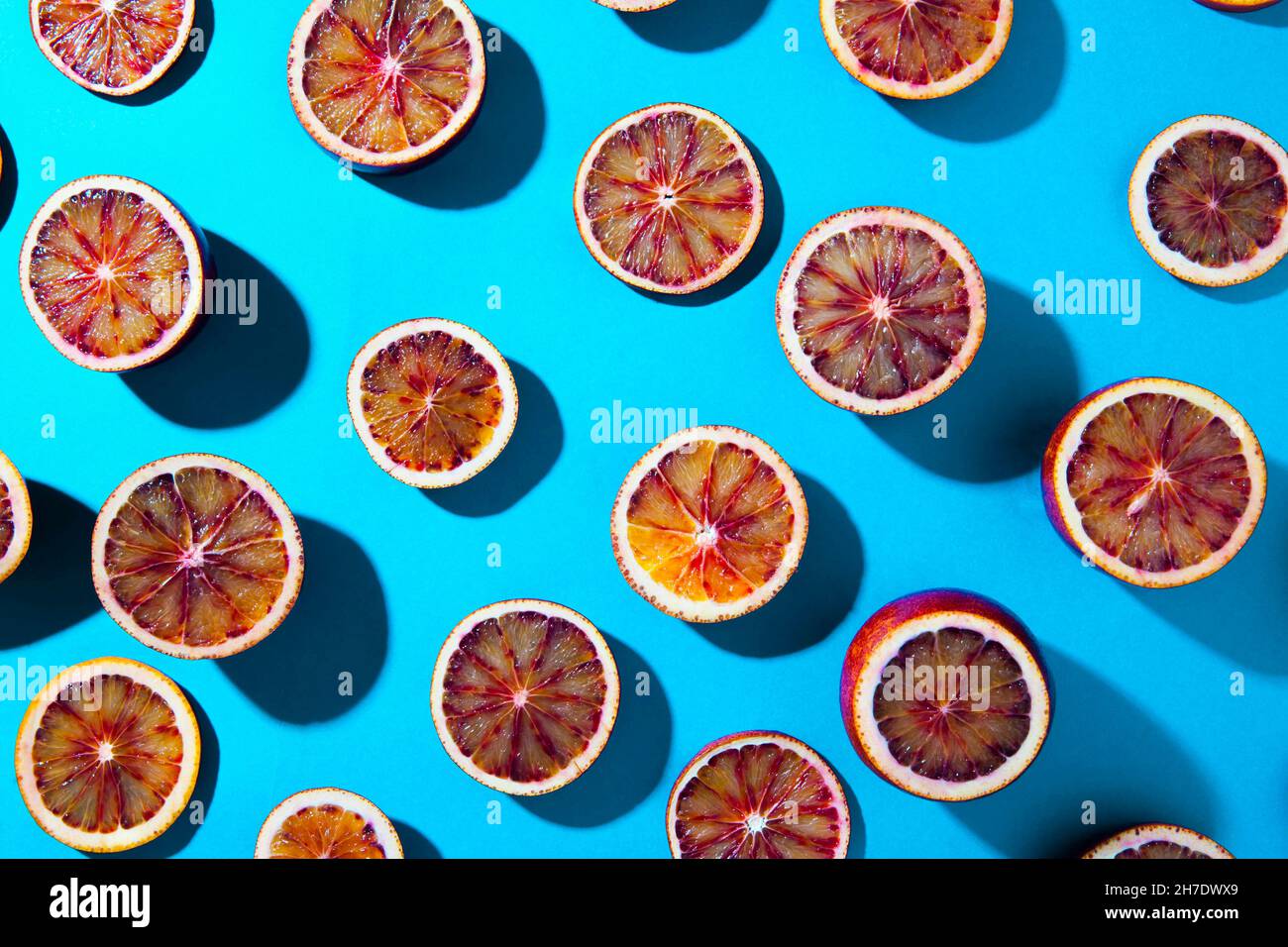 Blood orange halves on a turquoise background Stock Photo - Alamy