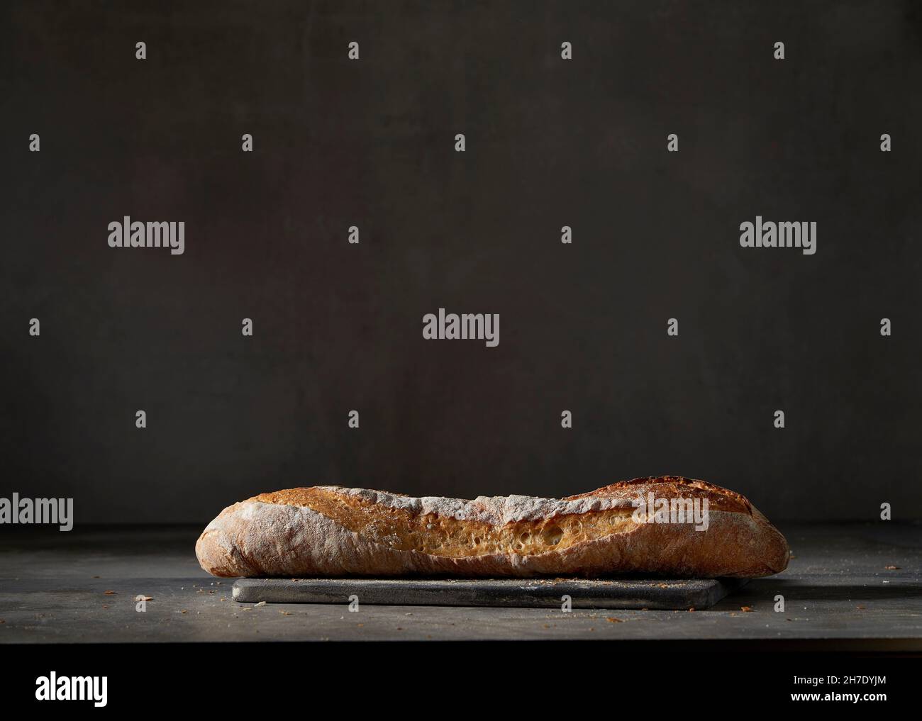 A baguette in front of a dark background Stock Photo - Alamy