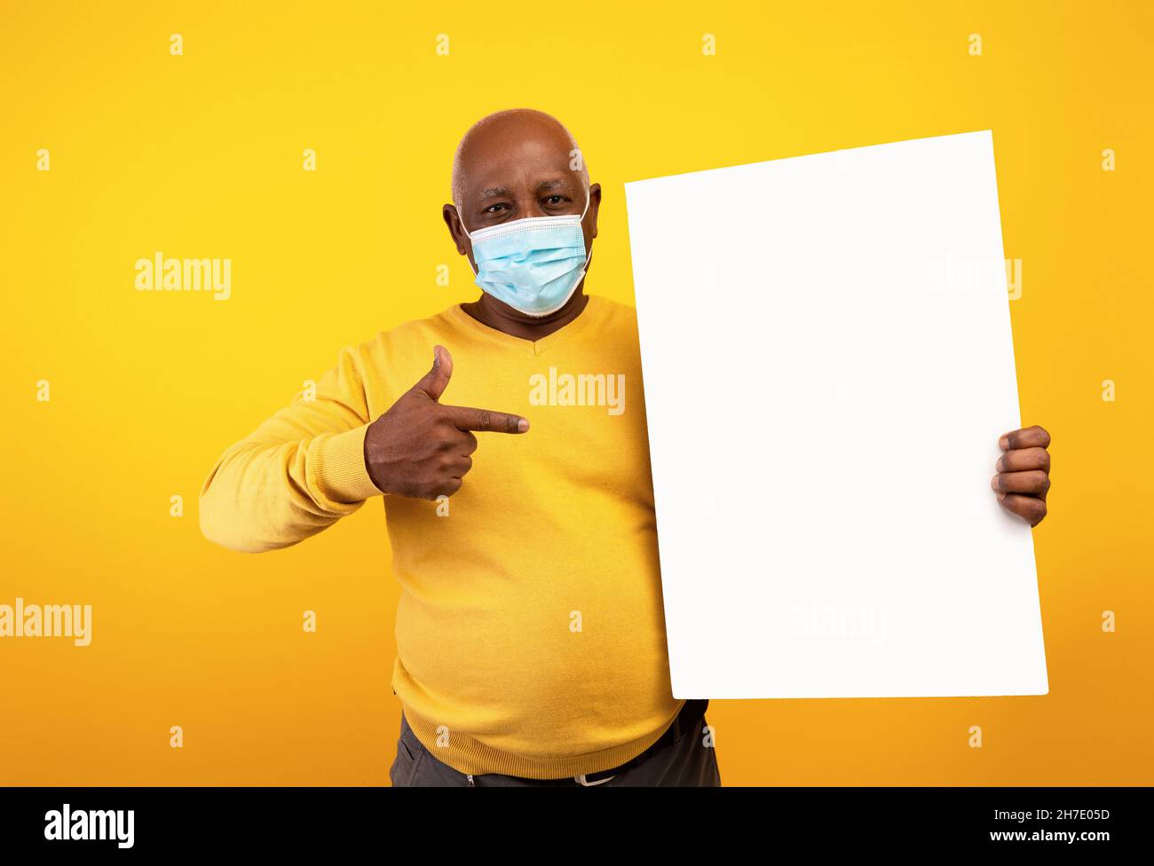 Senior African American man wearing face mask, showing blank white ...