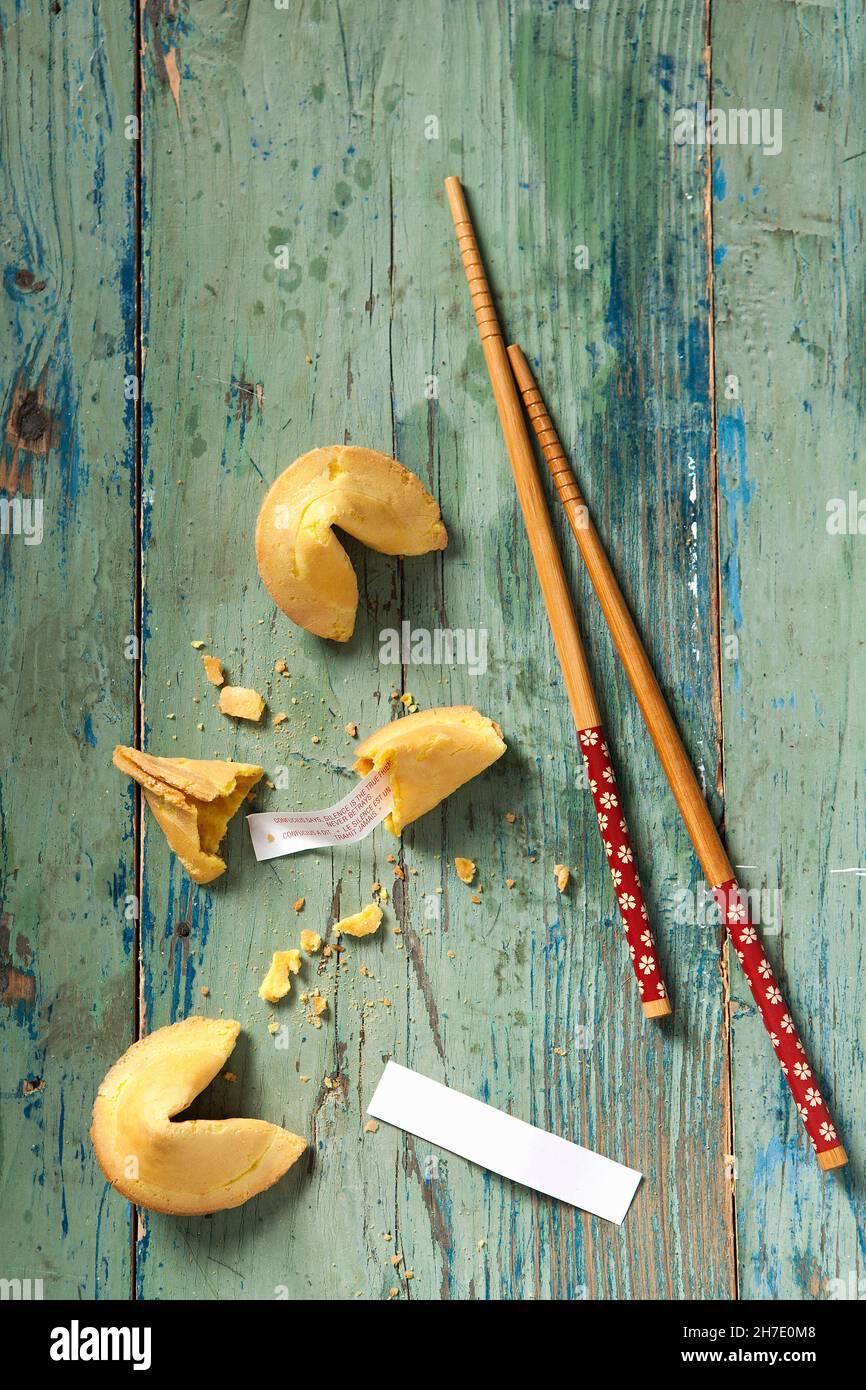 Three fourtune cookies one broken open with fortune paper coming out ...