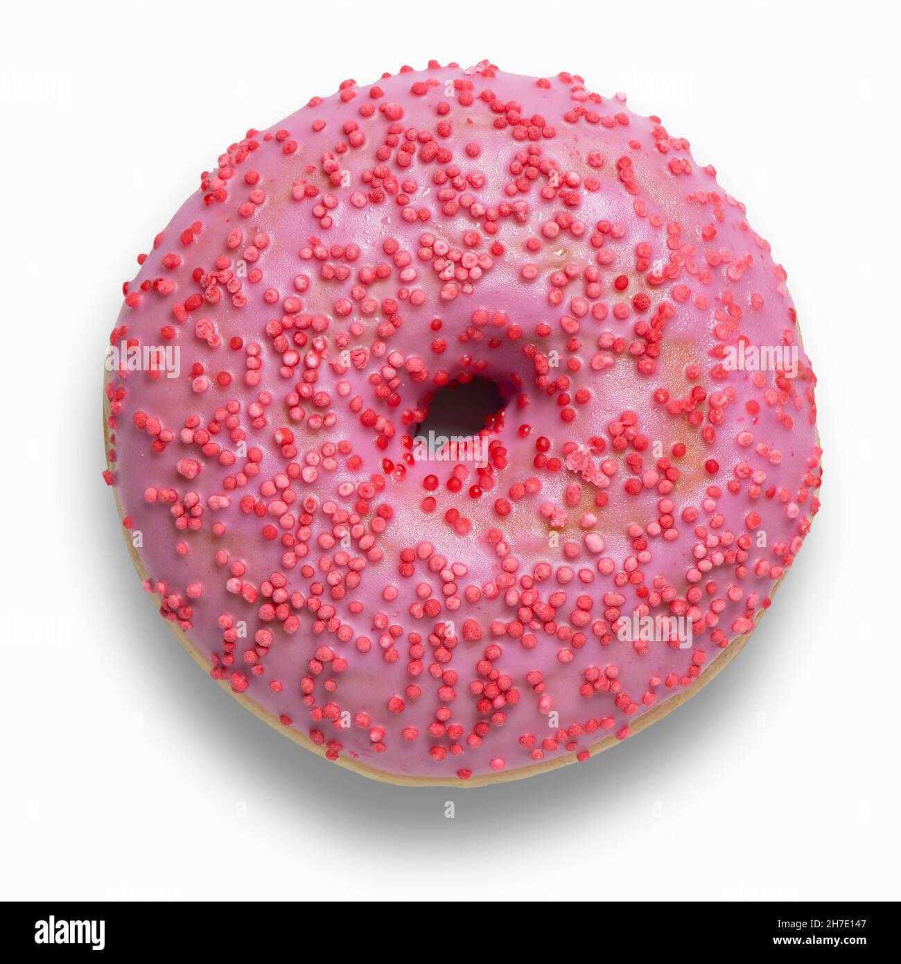 A pink doughnut decorated with red sugar sprinkles Stock Photo - Alamy
