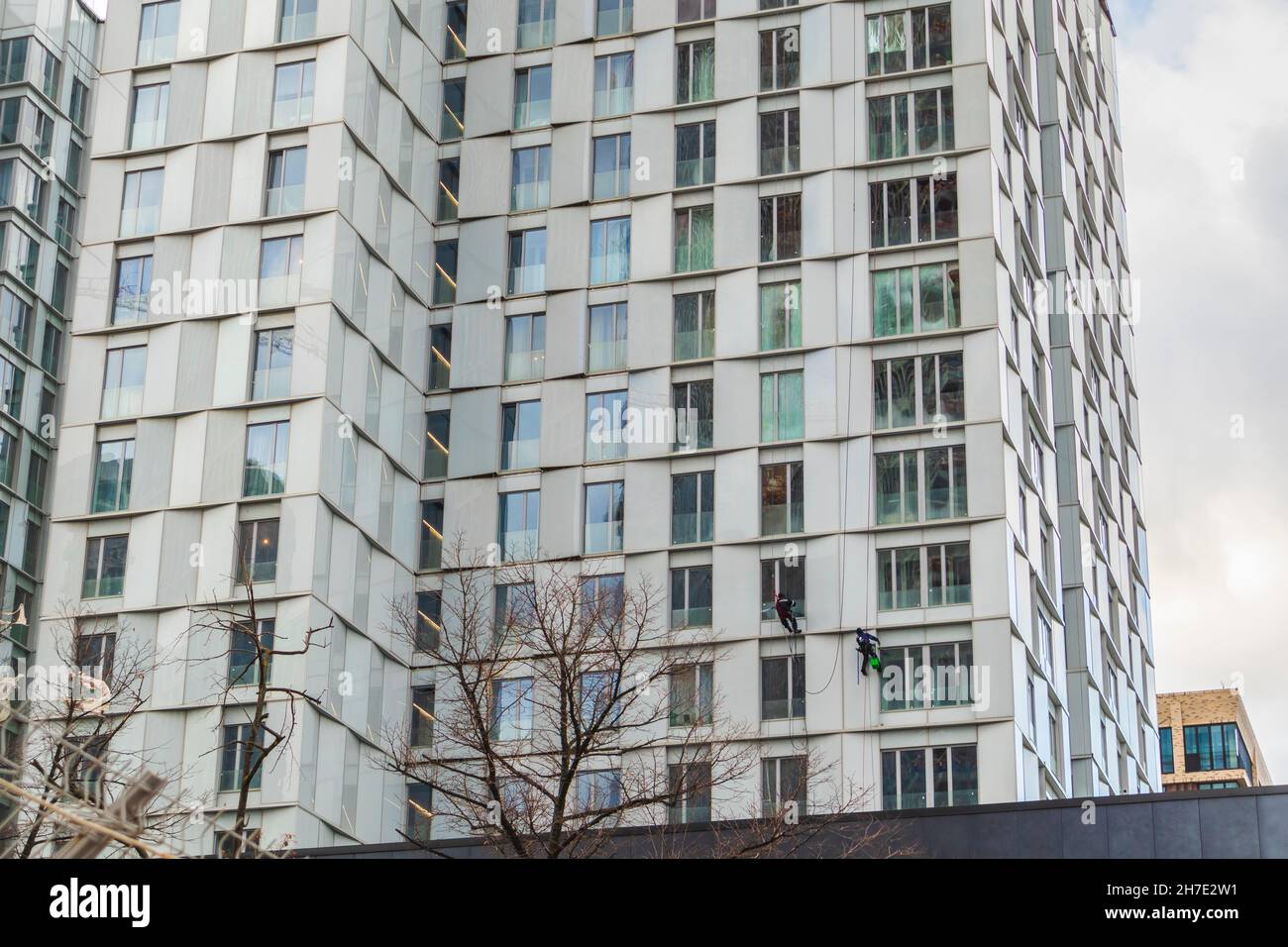 high-rise builders workers hanging on a skyscraper building city ...