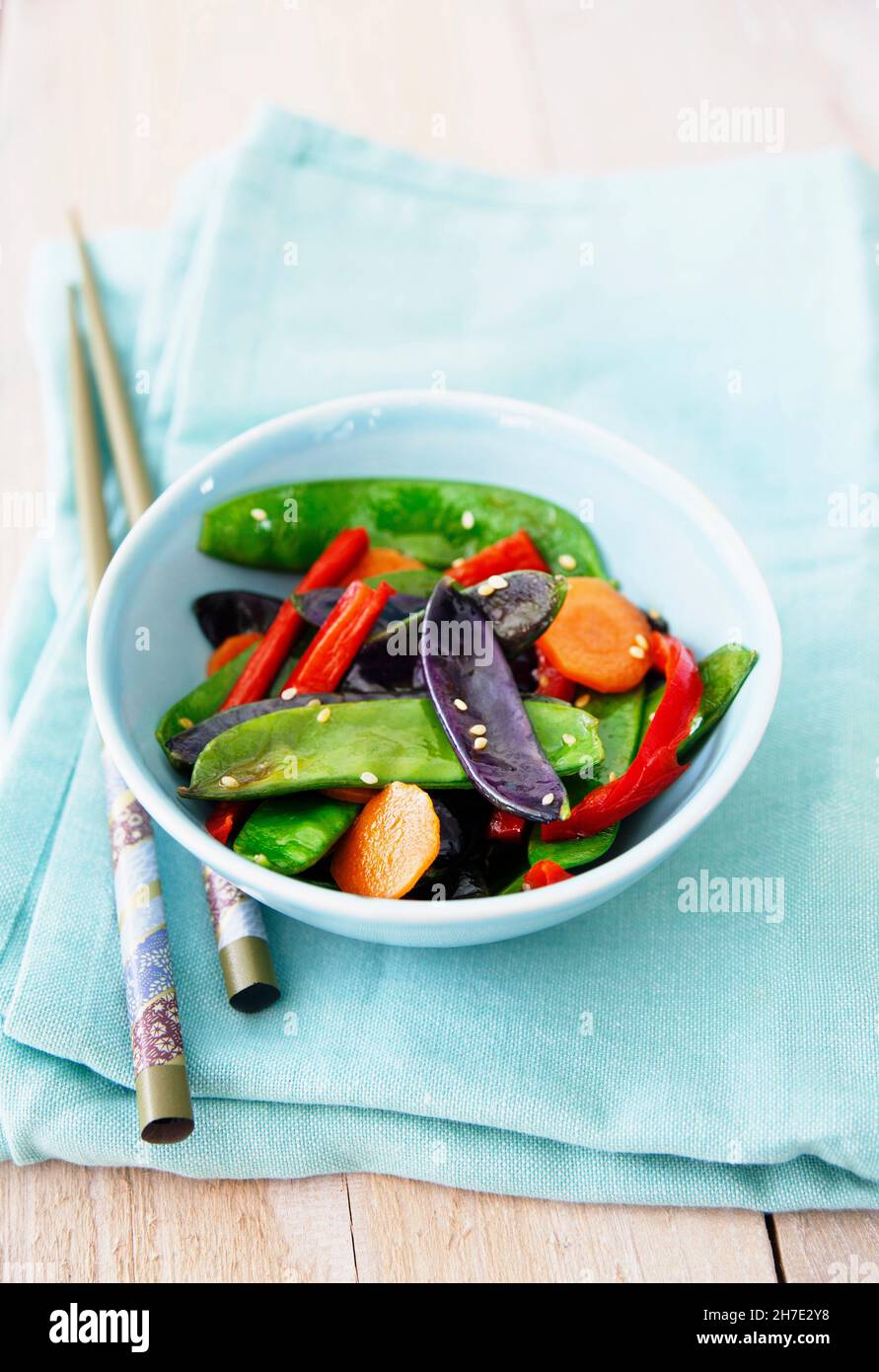 Fried purple and green mange tout with carrots and chilli Stock Photo ...