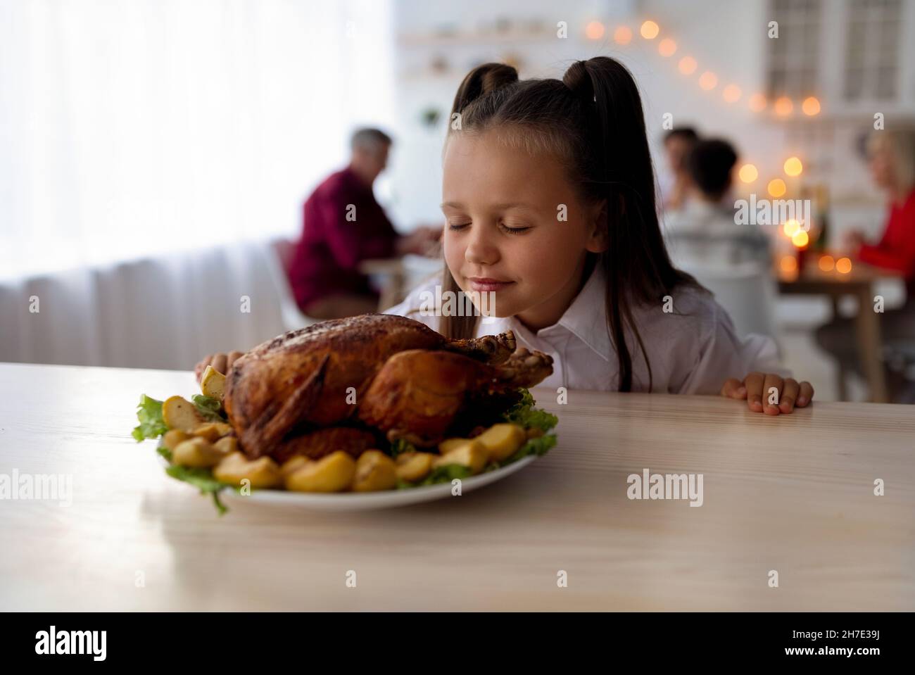 Little girl smelling yummy roasted turkey, having festive Thanksgiving ...