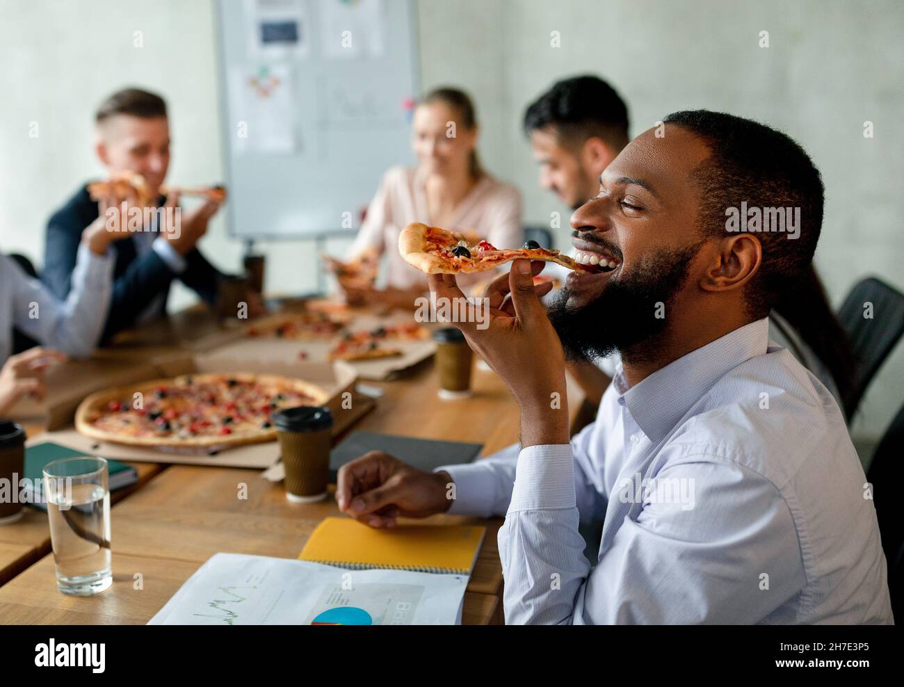 Corporate Lunch Break Group Of Colleagues Eating Takeaway Pizza In