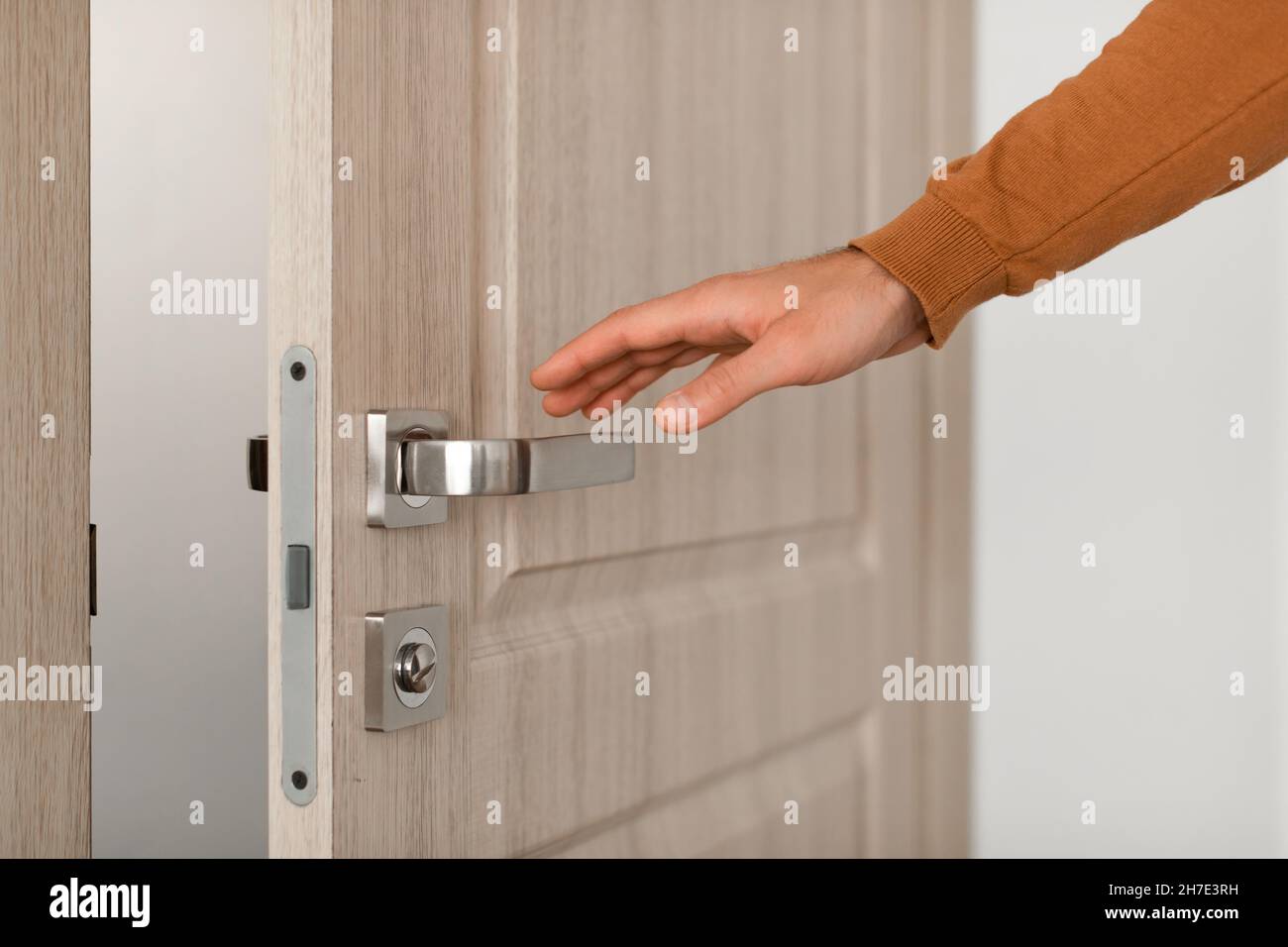 Closeup of guy opening wooden door, reaching hand to handle Stock Photo ...
