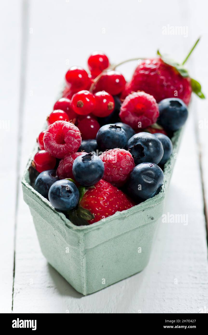 Various berries in a cardboard punnet Stock Photo - Alamy