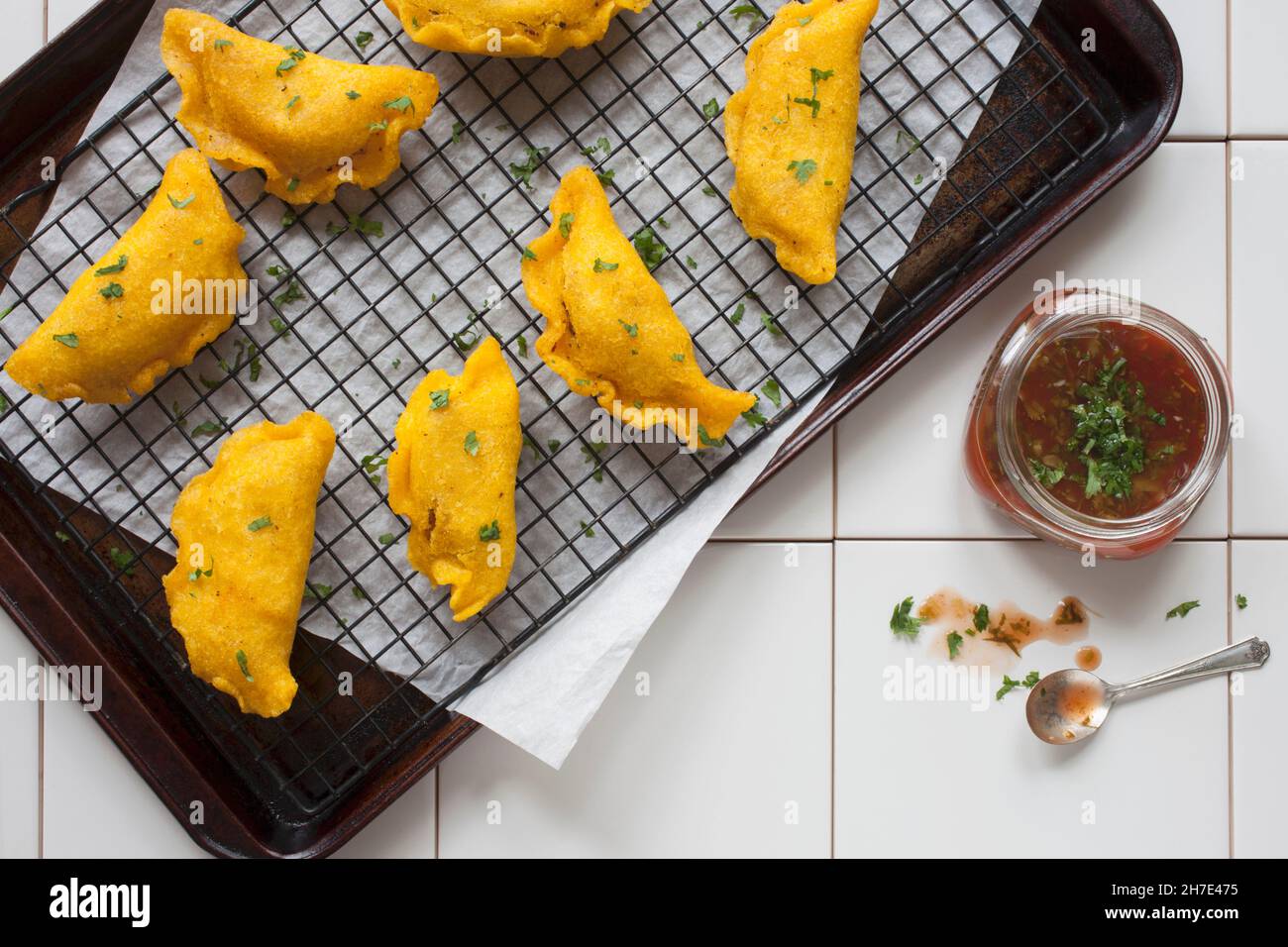 Colombian empanadas on a cooling rack with salsa (seen from above Stock ...