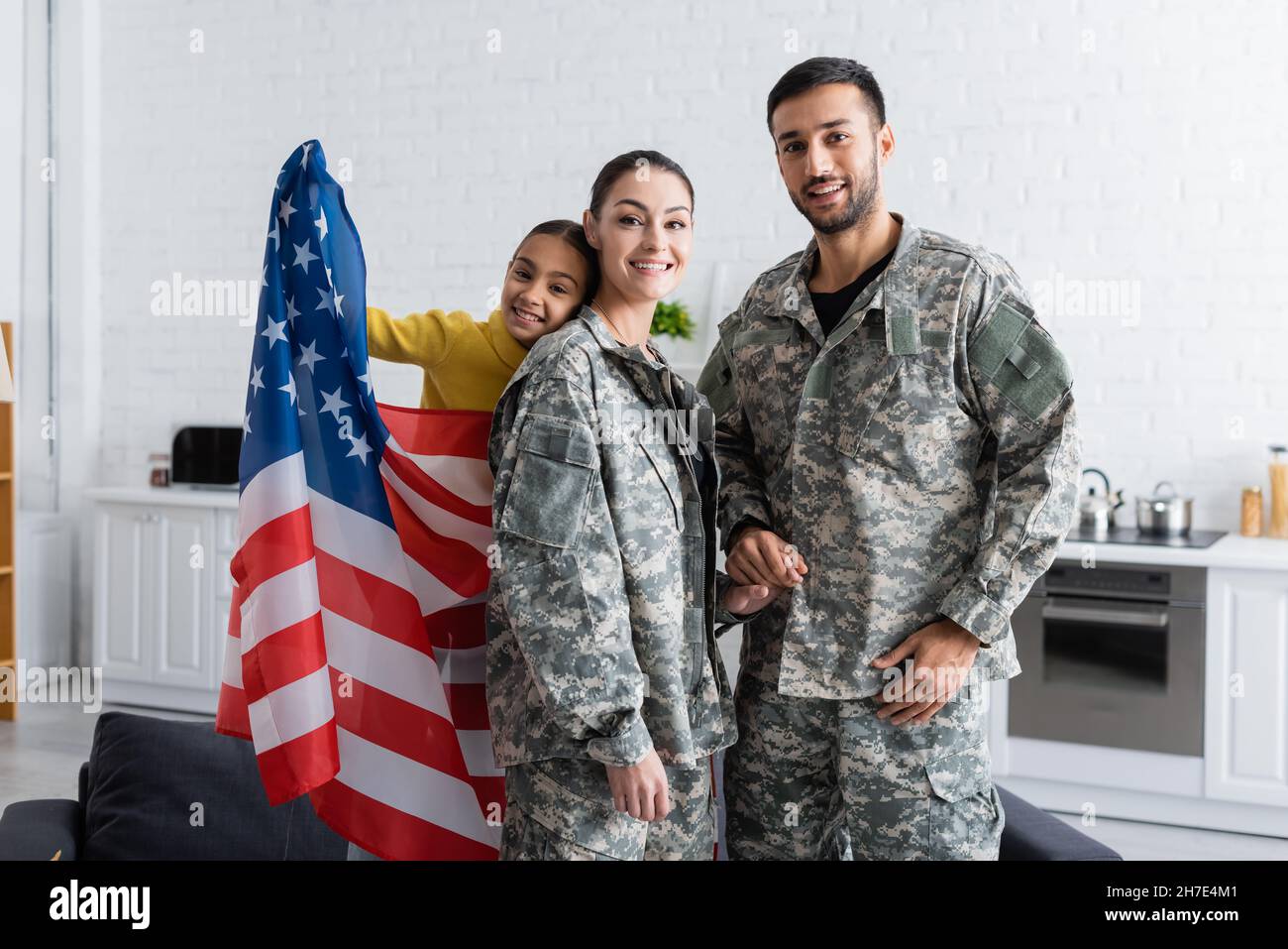 Parents in military uniform holding hands near preteen kid with ...