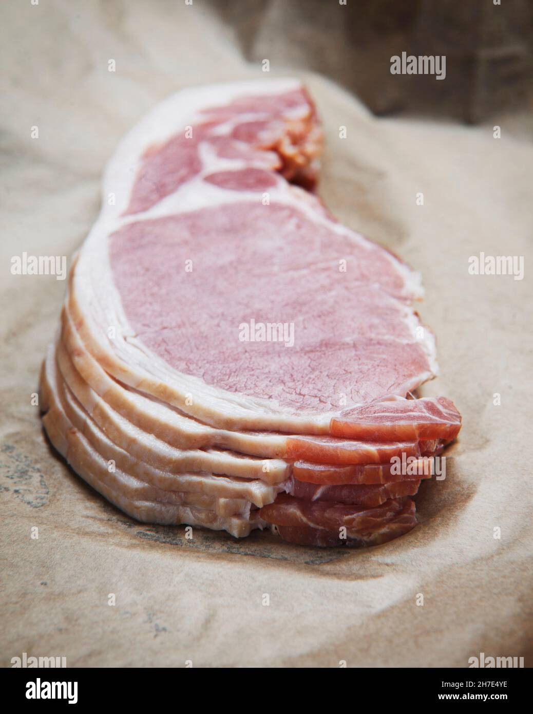 A stack of raw bacon on parchment paper Stock Photo - Alamy