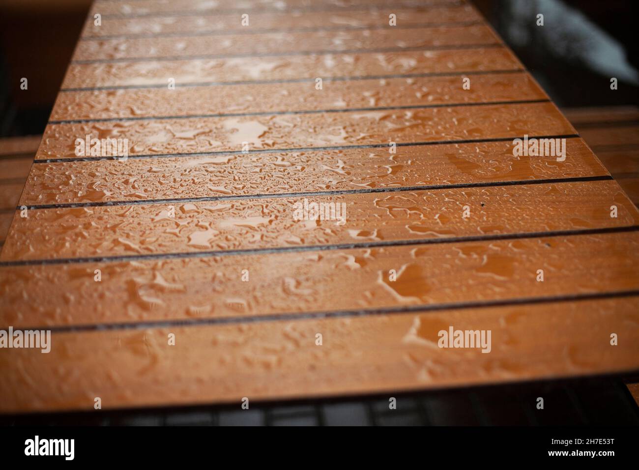 Wet board. Water droplets on the surface. Details of the bench in rainy ...