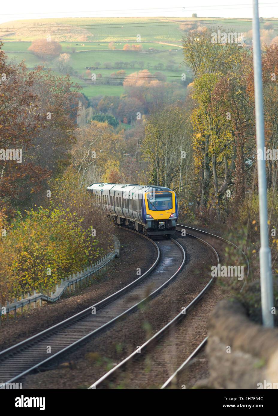 A Northern rail train passes through Calderdale beside the A58 main ...