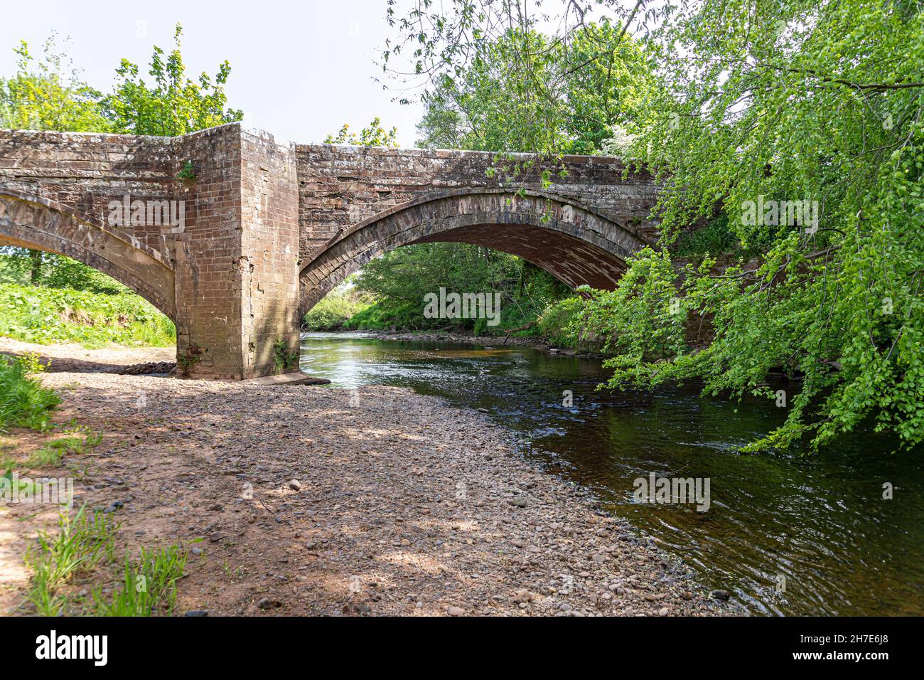 The red sandstone bridge begun in 1753 over the River Irthing at ...