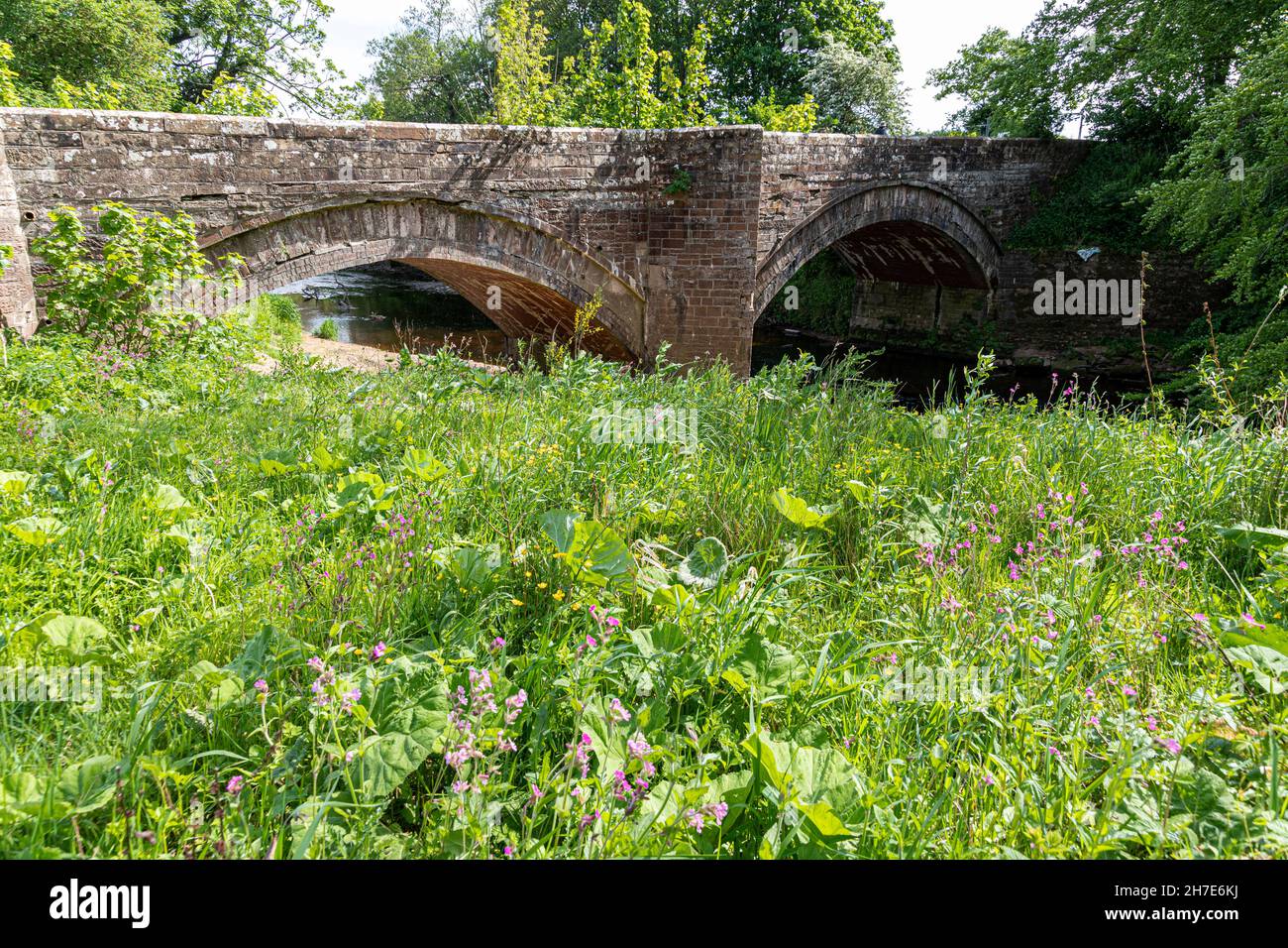 The red sandstone bridge begun in 1753 over the River Irthing at ...