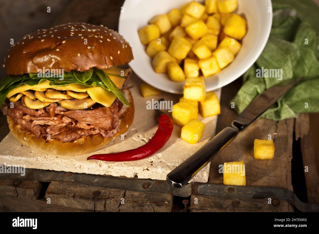 A burger with fried potato cubes Stock Photo - Alamy