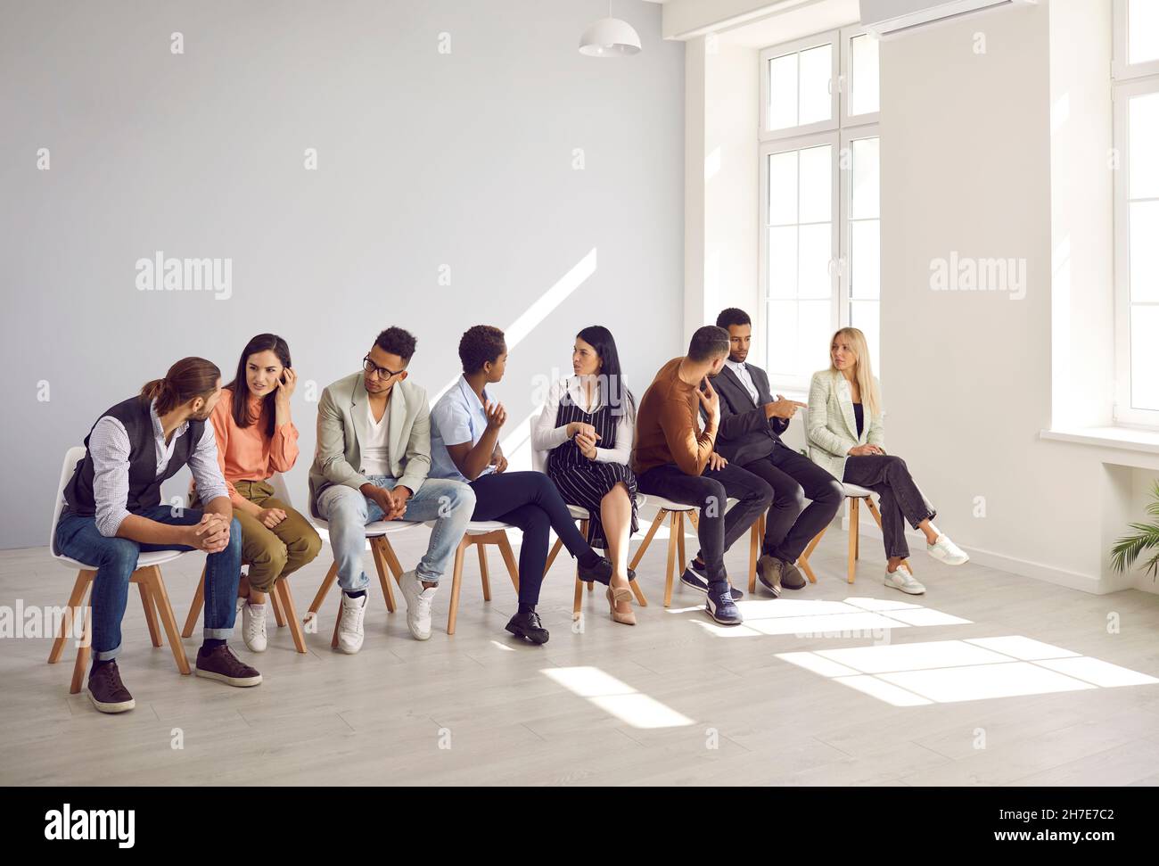 Different people sit in lines in row and communicate in groups ...