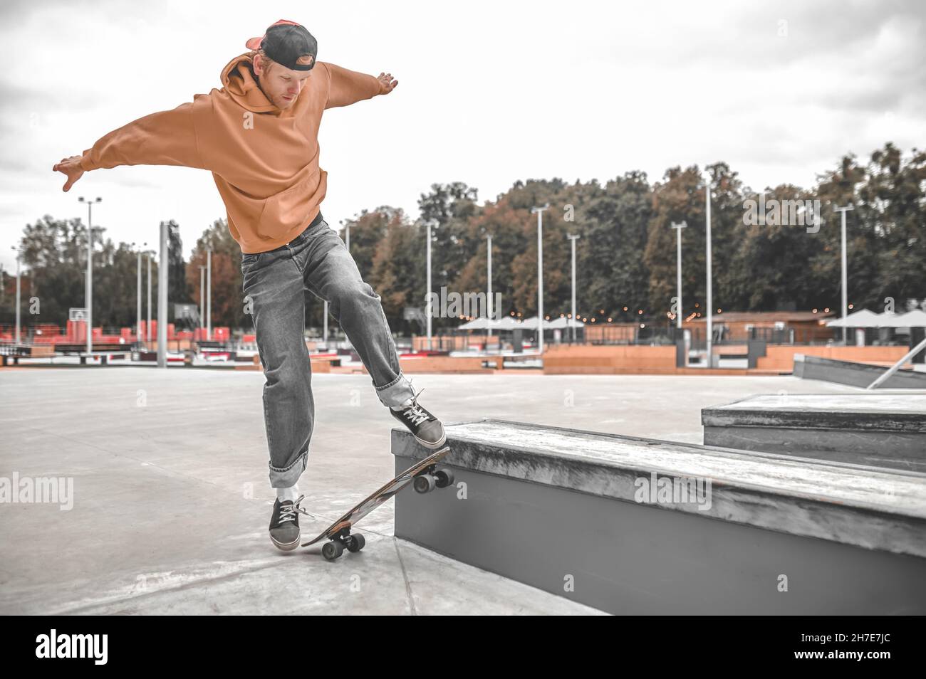 Guy with skateboard jumping off curb Stock Photo - Alamy