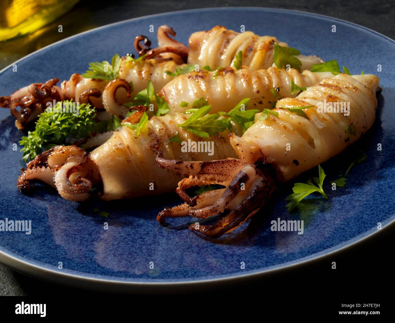 Whole grilled calamari with garlic and parsley Stock Photo - Alamy
