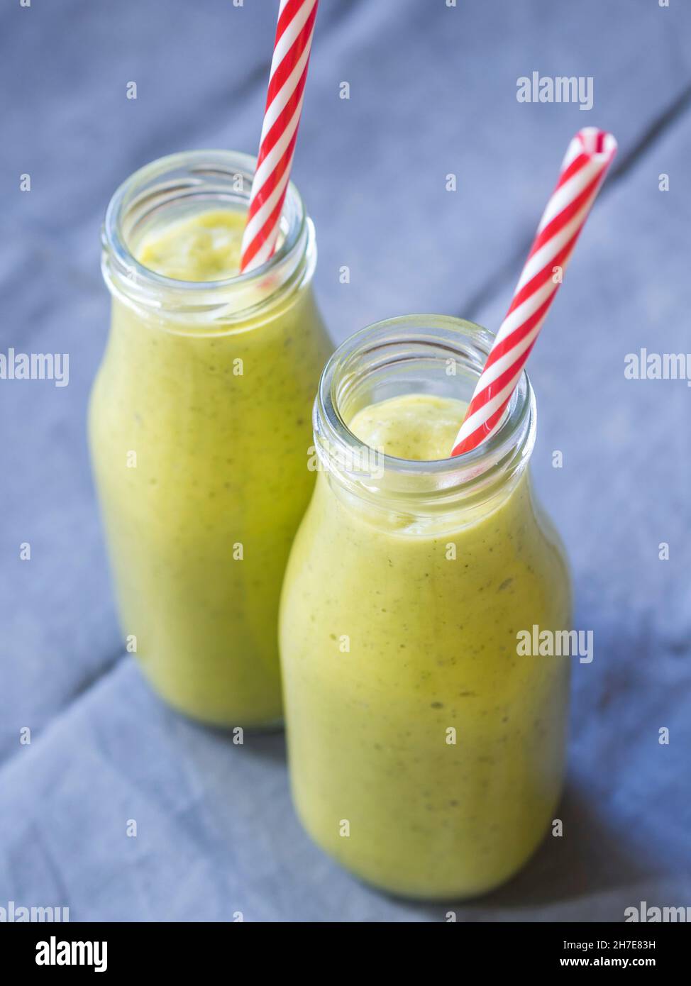 Two bottels of green smoothie on a blue surface Stock Photo - Alamy