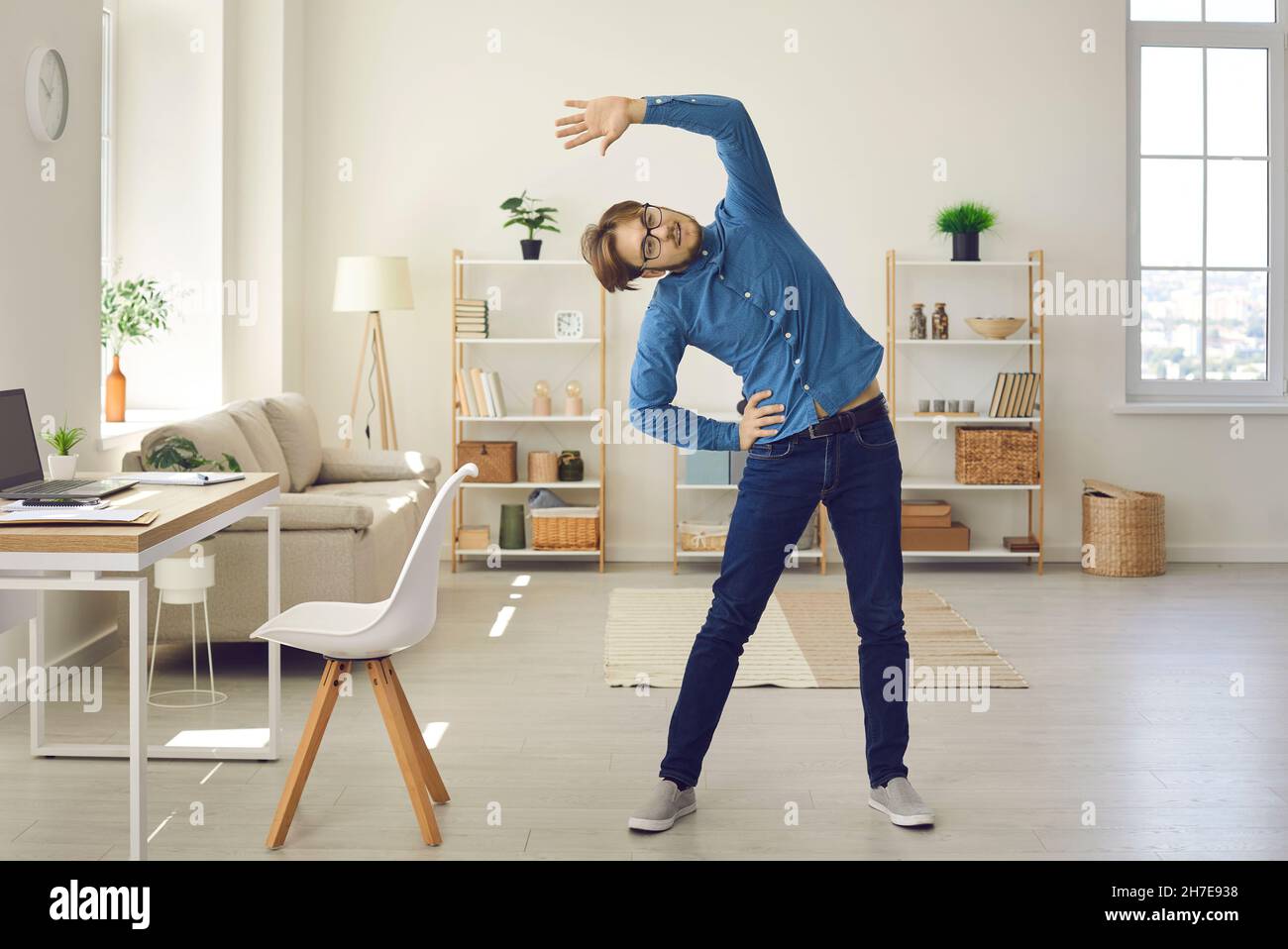Young man doing stretching exercise while having fitness workout at ...
