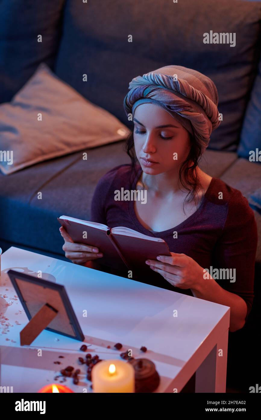 Beginner fortune-teller with an open handbook at the divination table ...