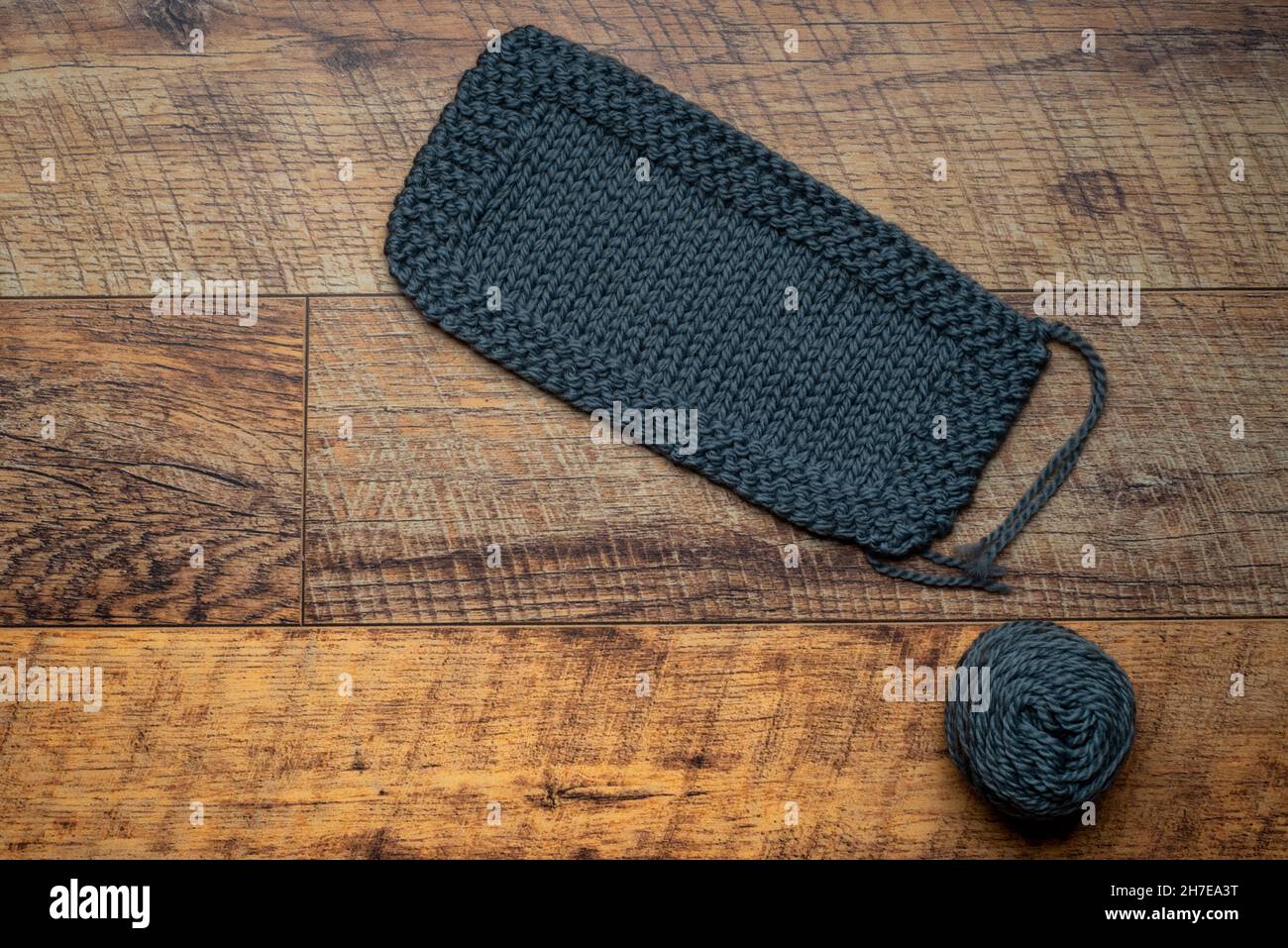 Blue yarn knitted swatch, wooden background testing a wool with knitted ...