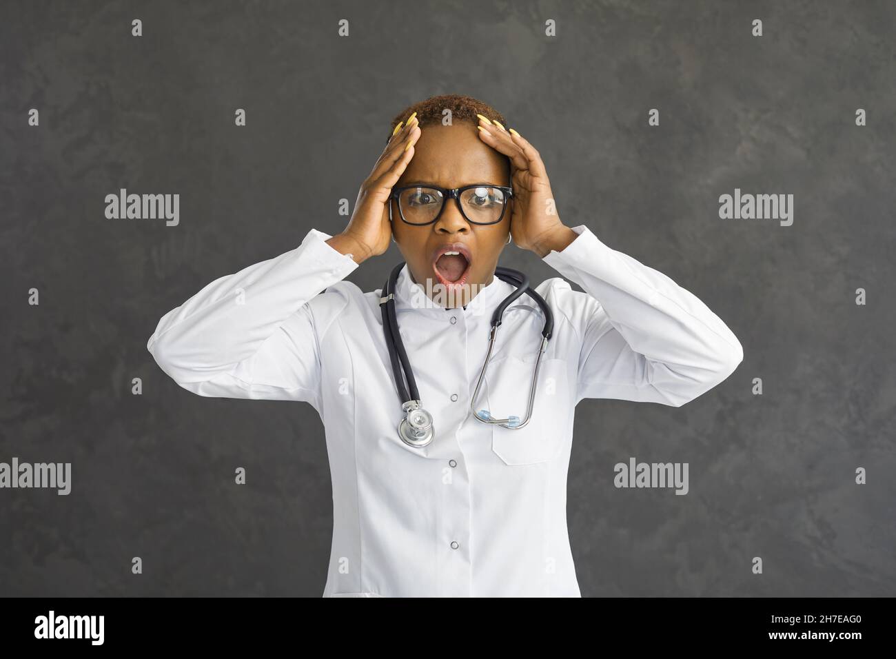Young black female nurse or doctor looking at something with shocked ...