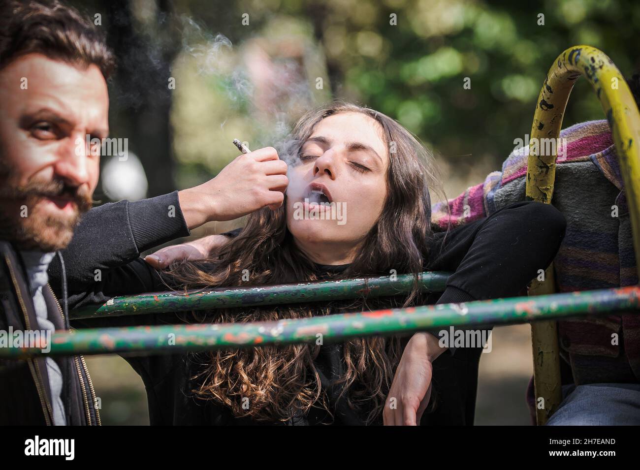 Group of young friends, female and male, smoking cannabis marijuana ...