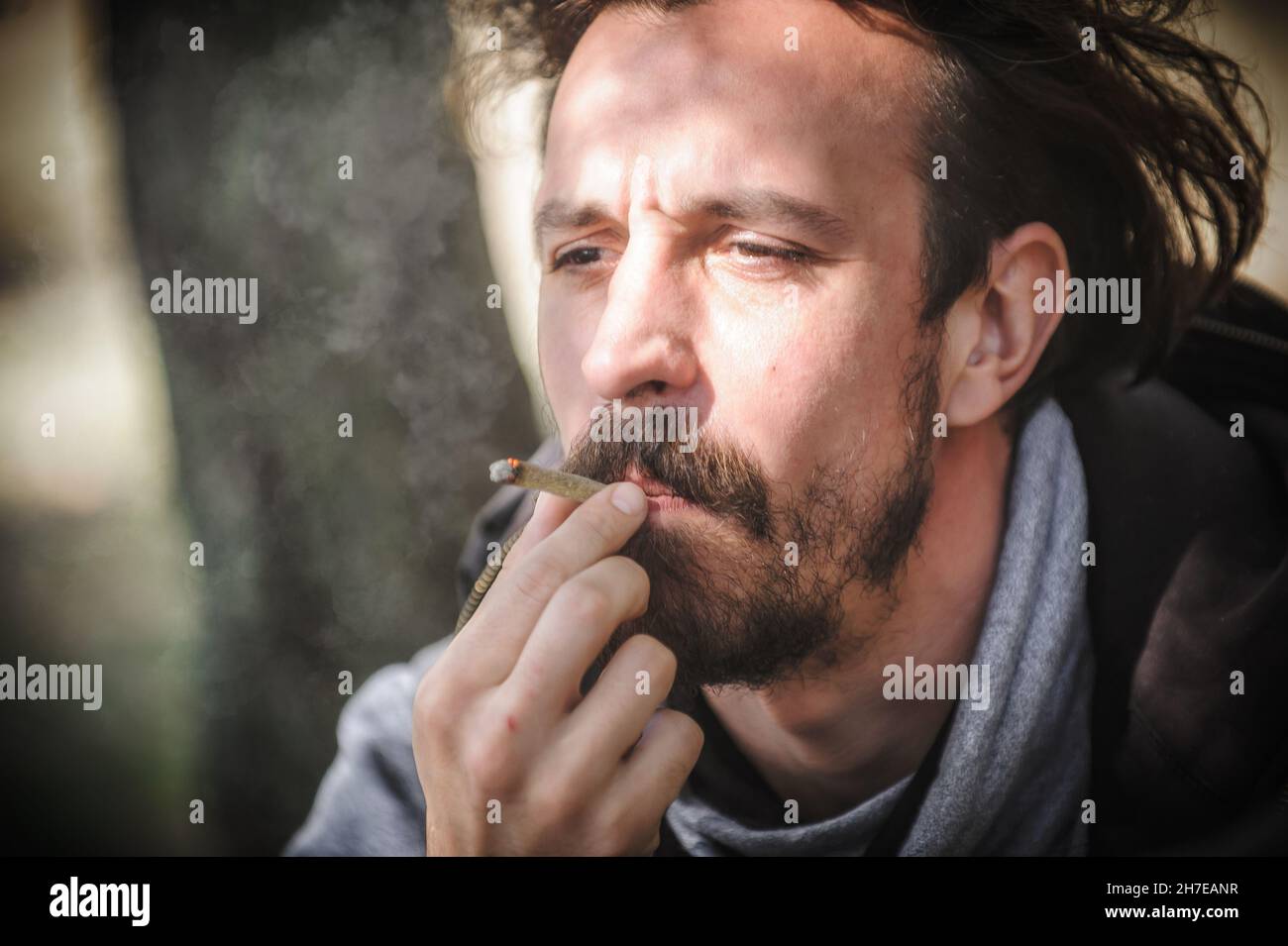 Closeup detail view of young man smoke cannabis marijuana ganja or ...