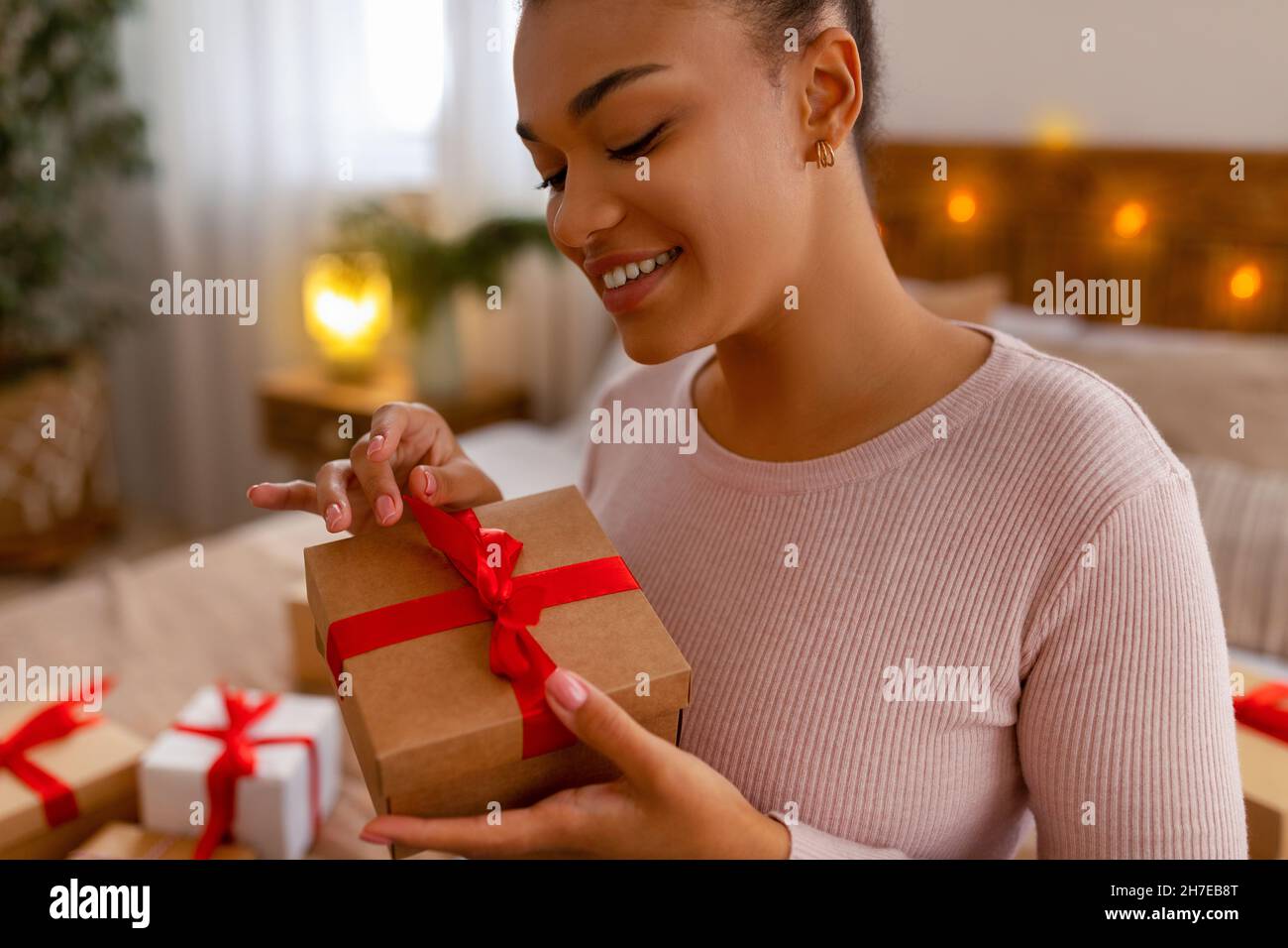 Christmas and new year celebration. Happy african american lady opening ...
