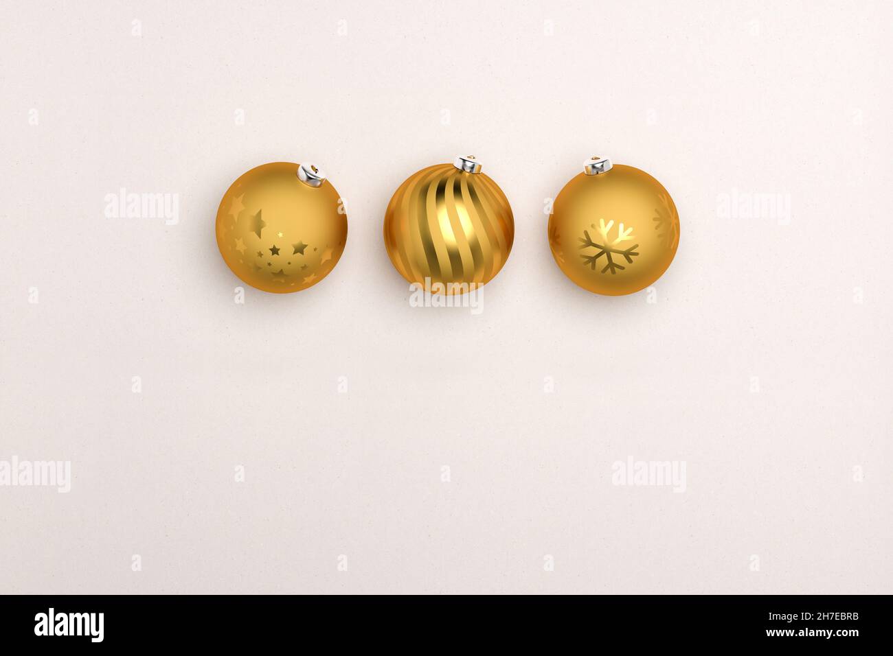 Three golden christmas baubles on paper background. Copy space below ...