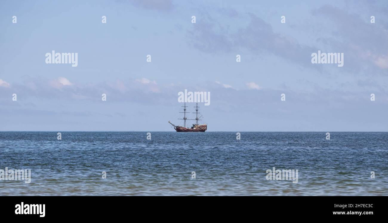 Large pirate ship against a blue cloudy sky sailing on the sea with ...