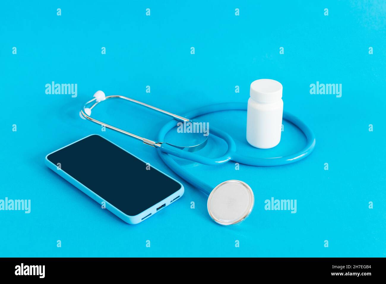 Smartphone with a pill bottle and a stethoscope on a blue surface Stock ...