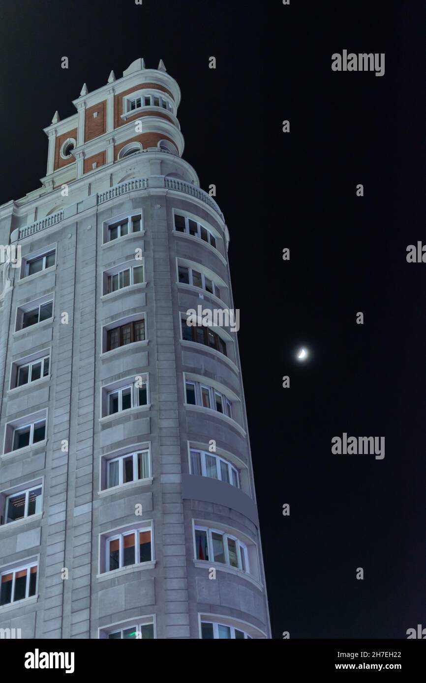 Night view of illuminated building and the moon on Gran Via in Madrid ...