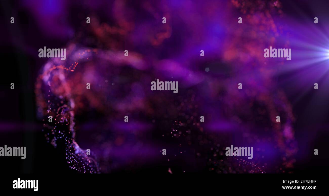 Image of red and pink particles moving in purple light on black ...