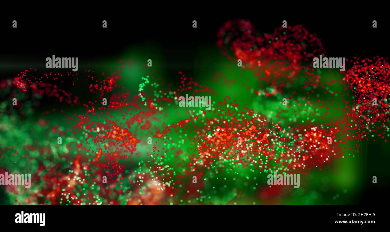 Image of green and red particles moving with green light on black ...