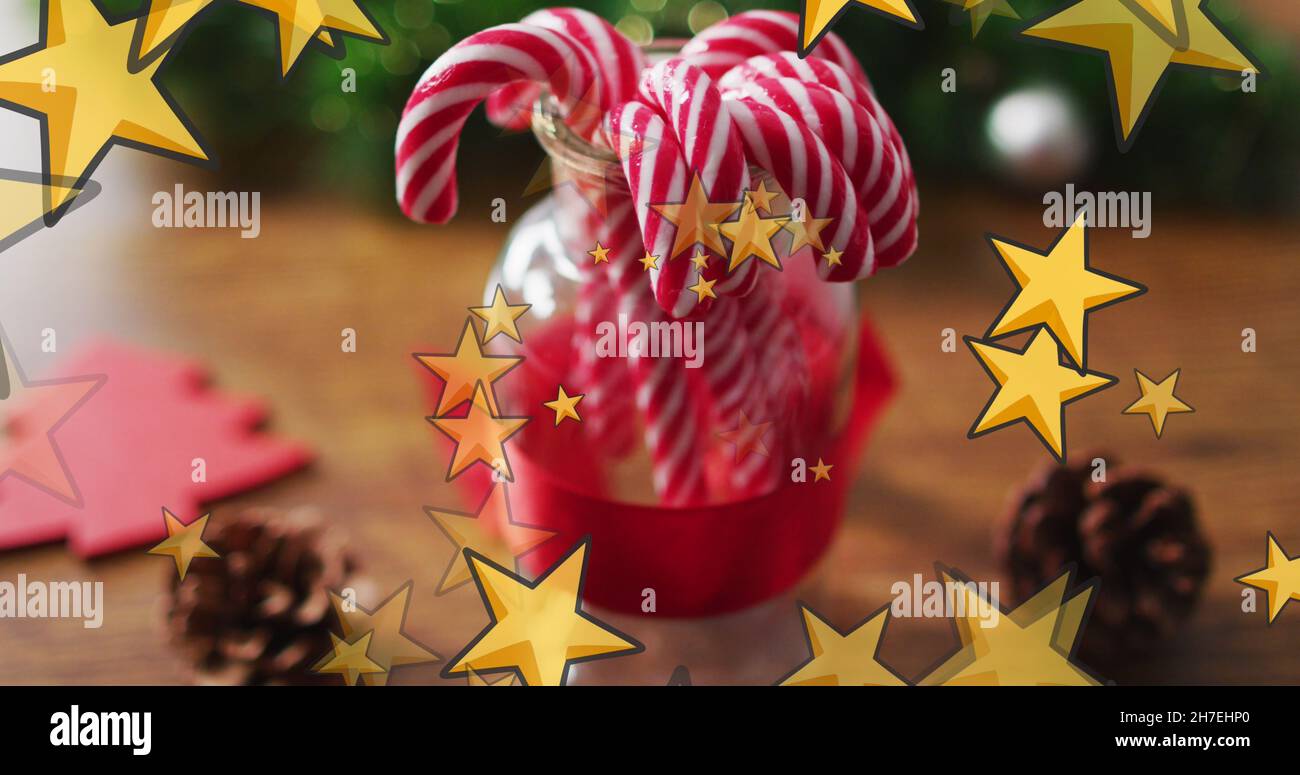 Image of gold stars moving over christmas candy canes and decorations ...
