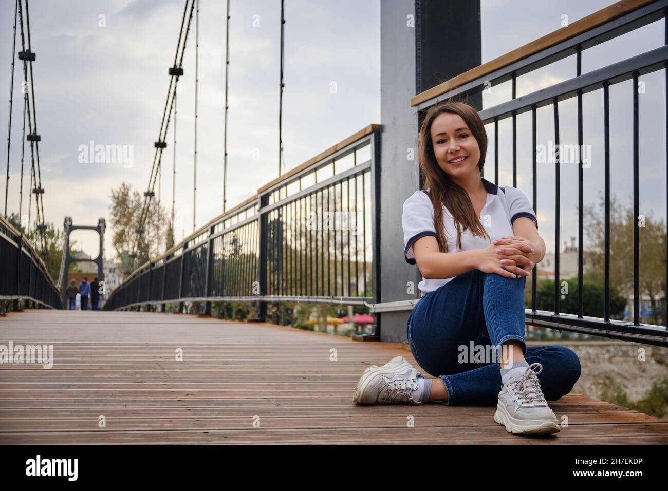 Woman sits on a pedestrian bridge Stock Photo - Alamy