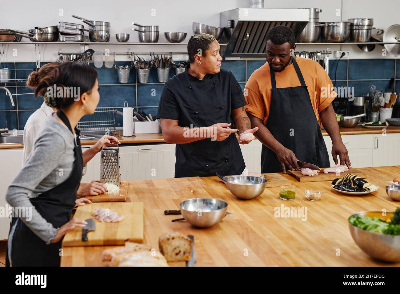 Portrait of diverse team of people cooking together in kitchen interior ...