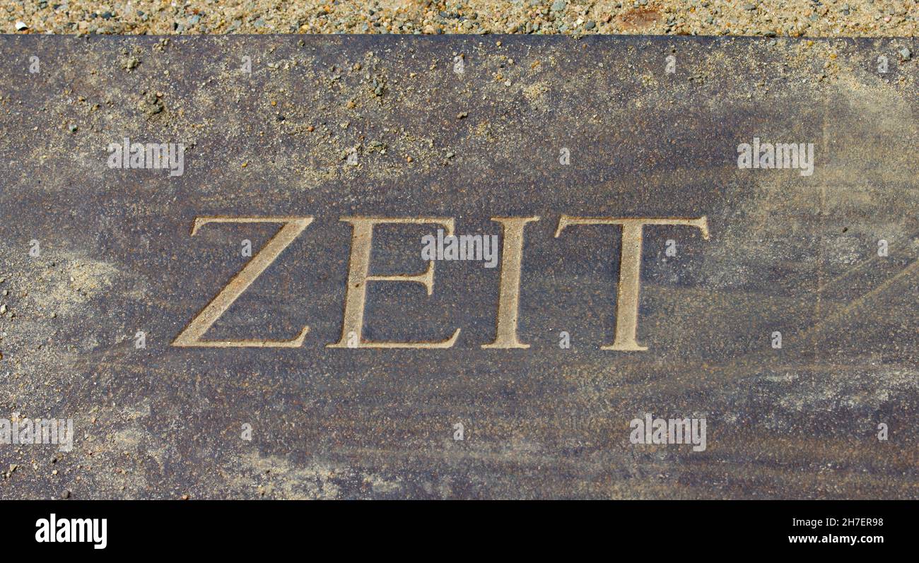 Engraved German word ZEIT partly covered in sand. Sands of Time Stock ...
